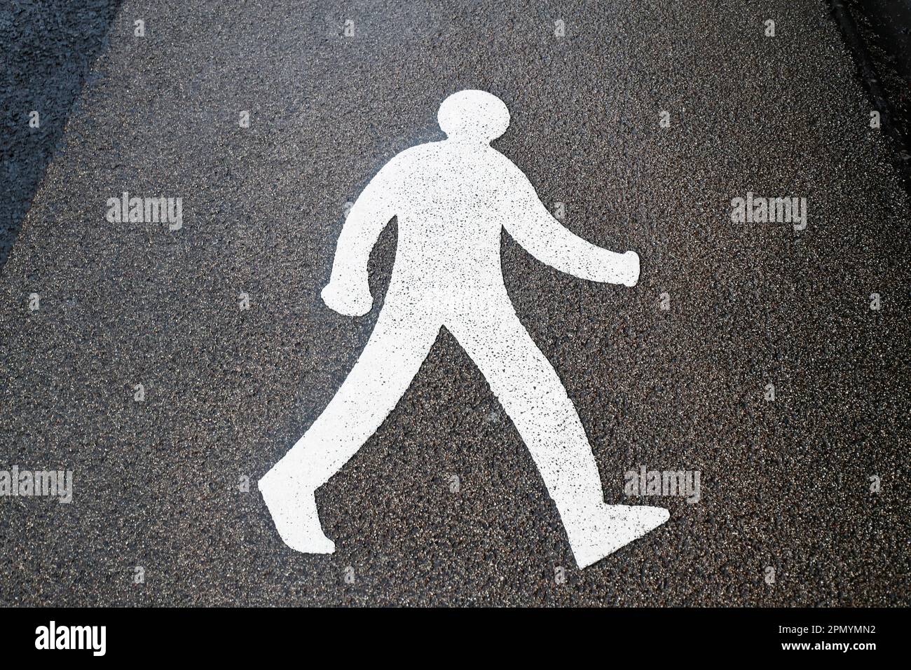 Pedestrian route depicted by a white walking man on the footpath Stock ...