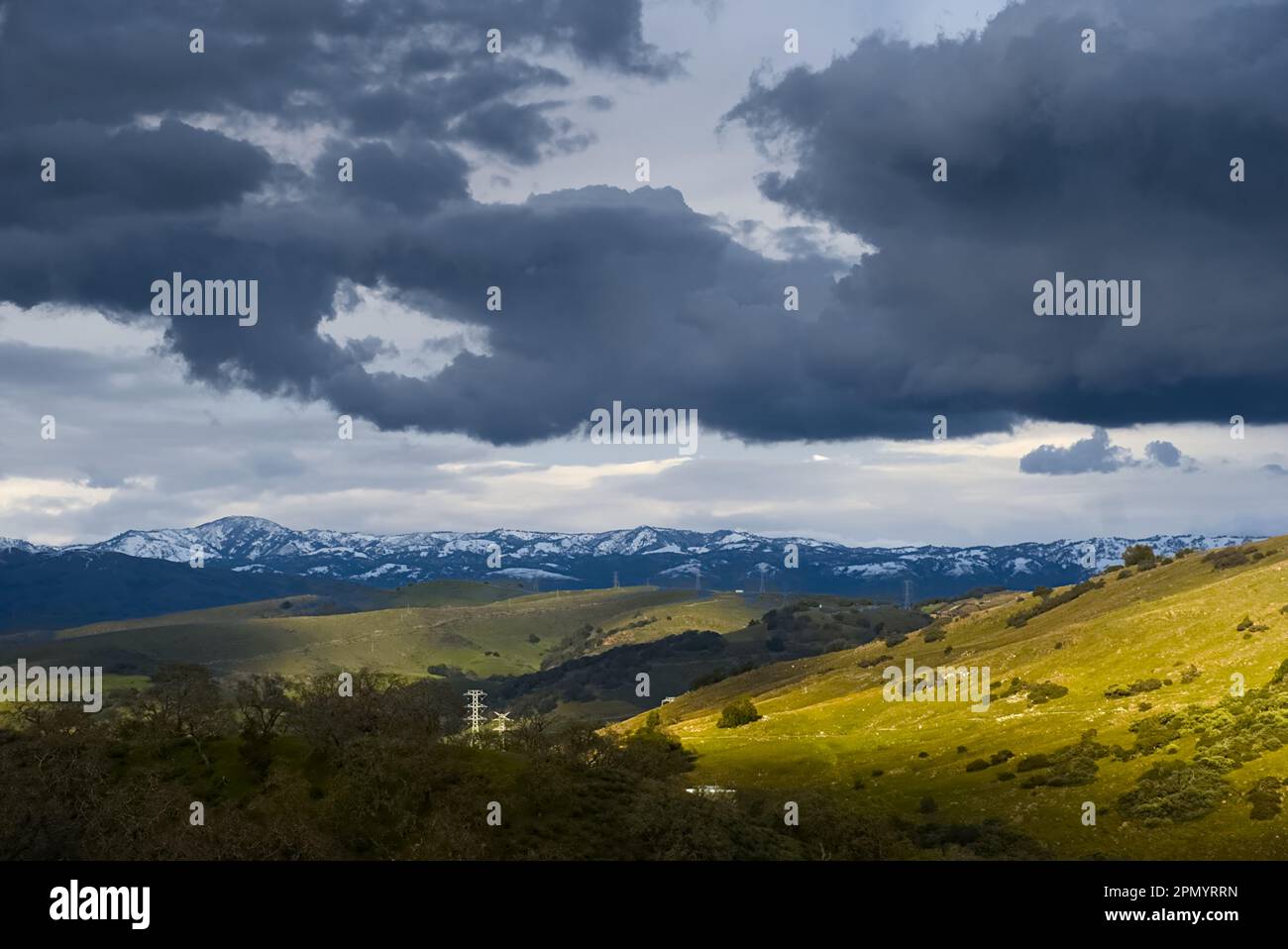 Green rolling hills under cloudy sky Stock Photo - Alamy