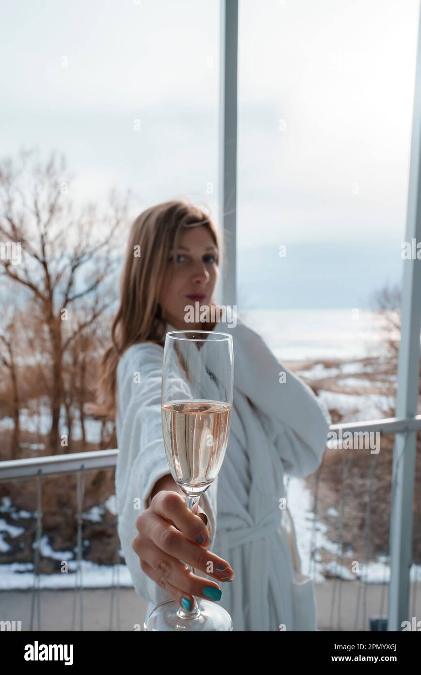 Woman holding champagne flute by window in luxury hotel Stock Photo - Alamy