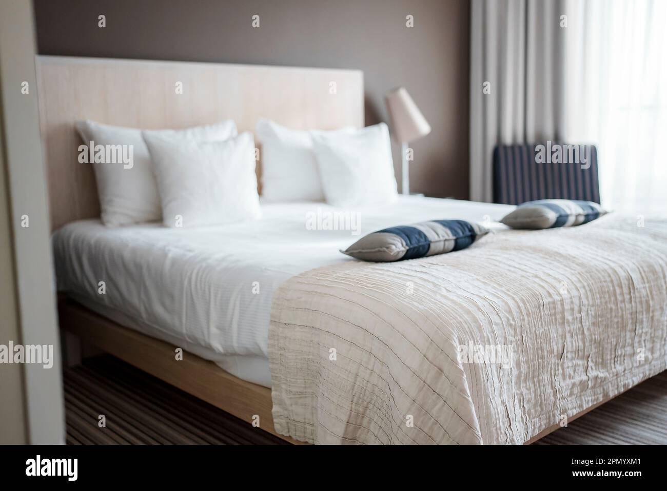 Interior of elegant bedroom with cushions and neat bed Stock Photo - Alamy