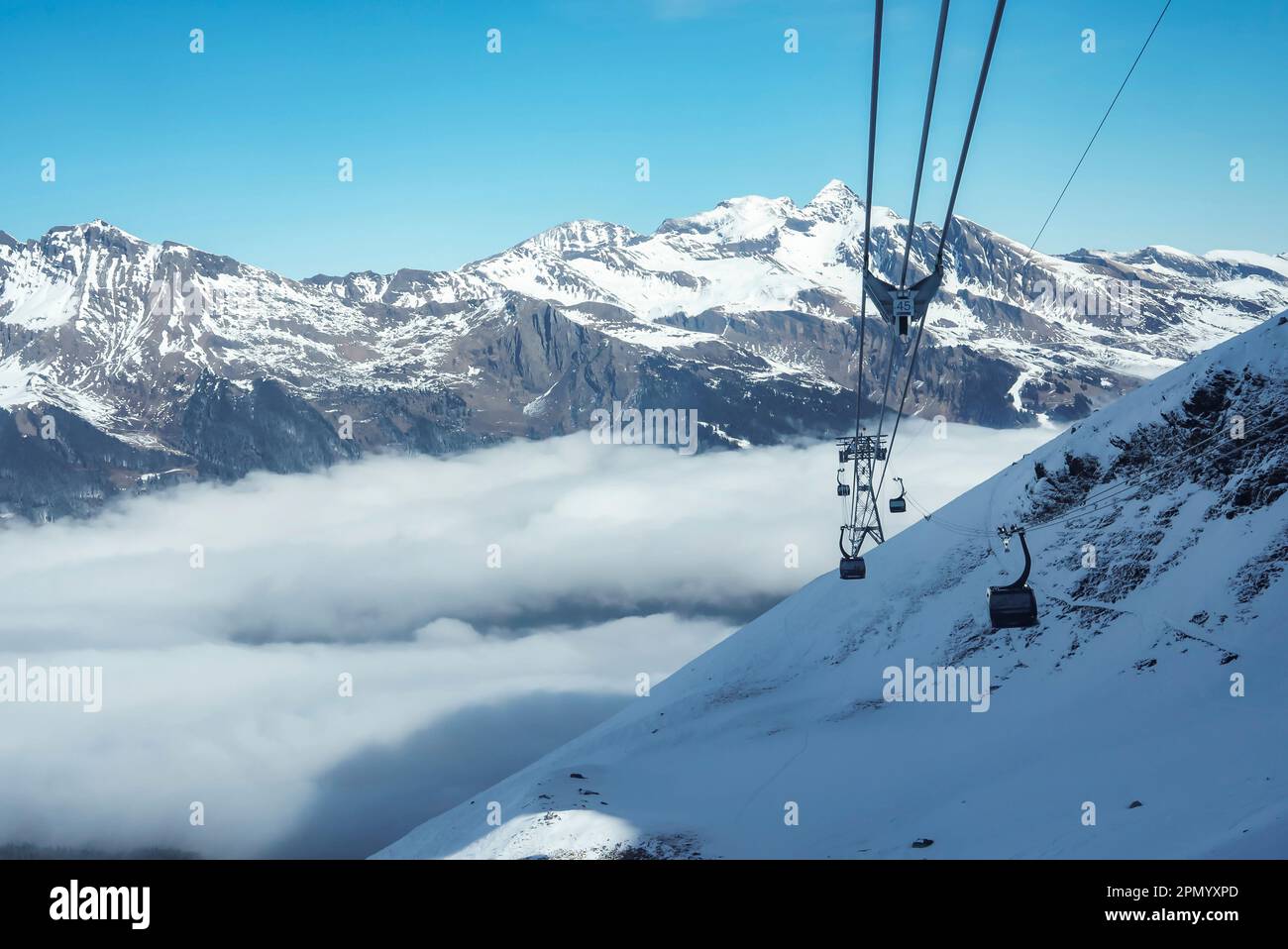 Cable cars moving over snow covered mountain at ski resort Stock Photo ...