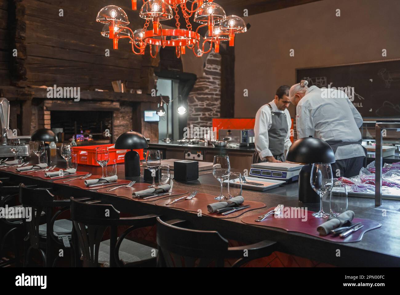 Chefs working in kitchen by dining table at luxury restaurant Stock ...
