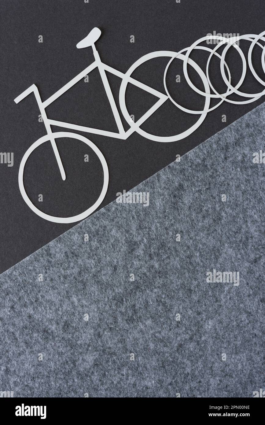 cut paper shape of a stylized bicycle rolling (imaginatively) down a ...