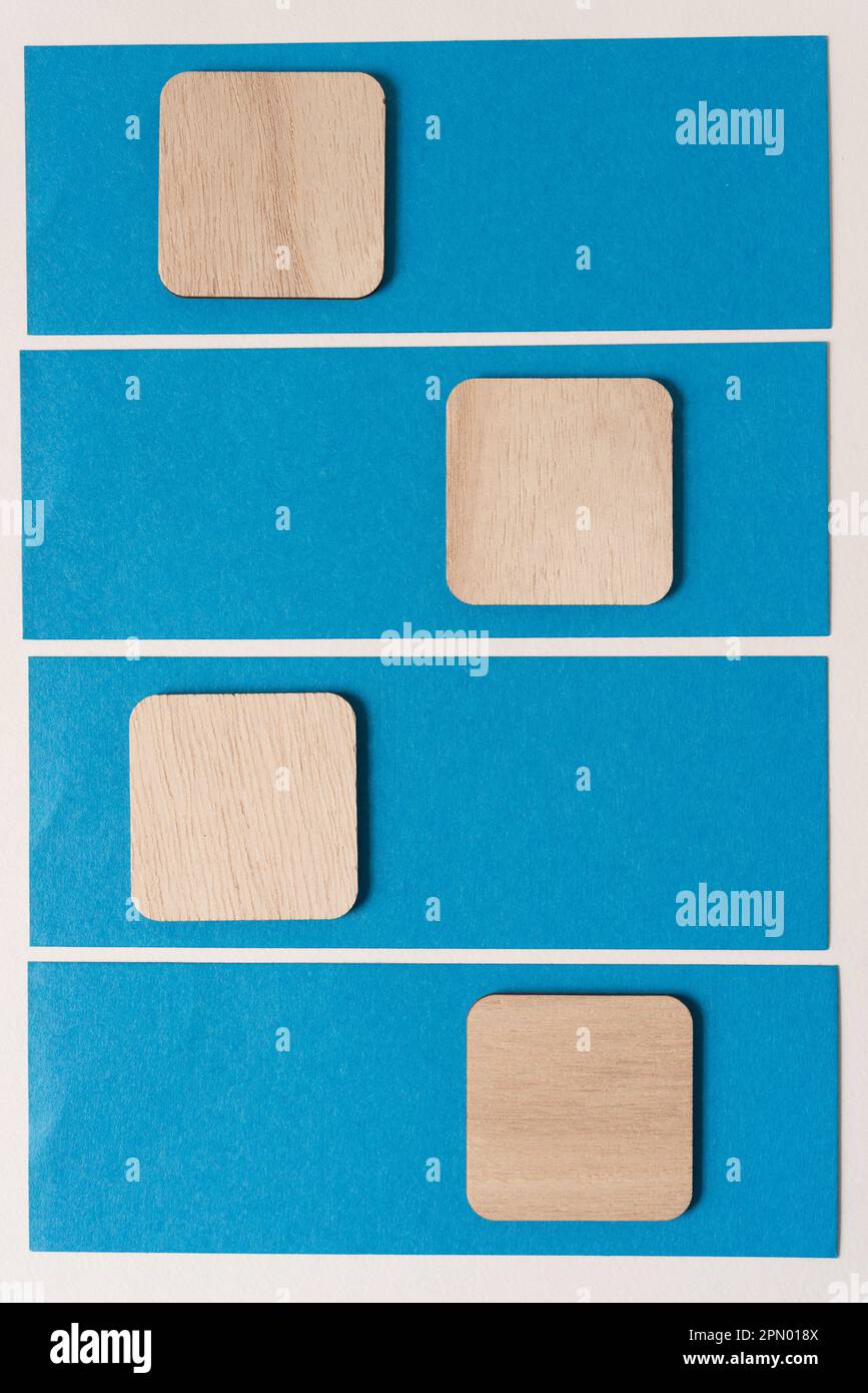 square wooden tags or objects on stripes of blue paper Stock Photo - Alamy
