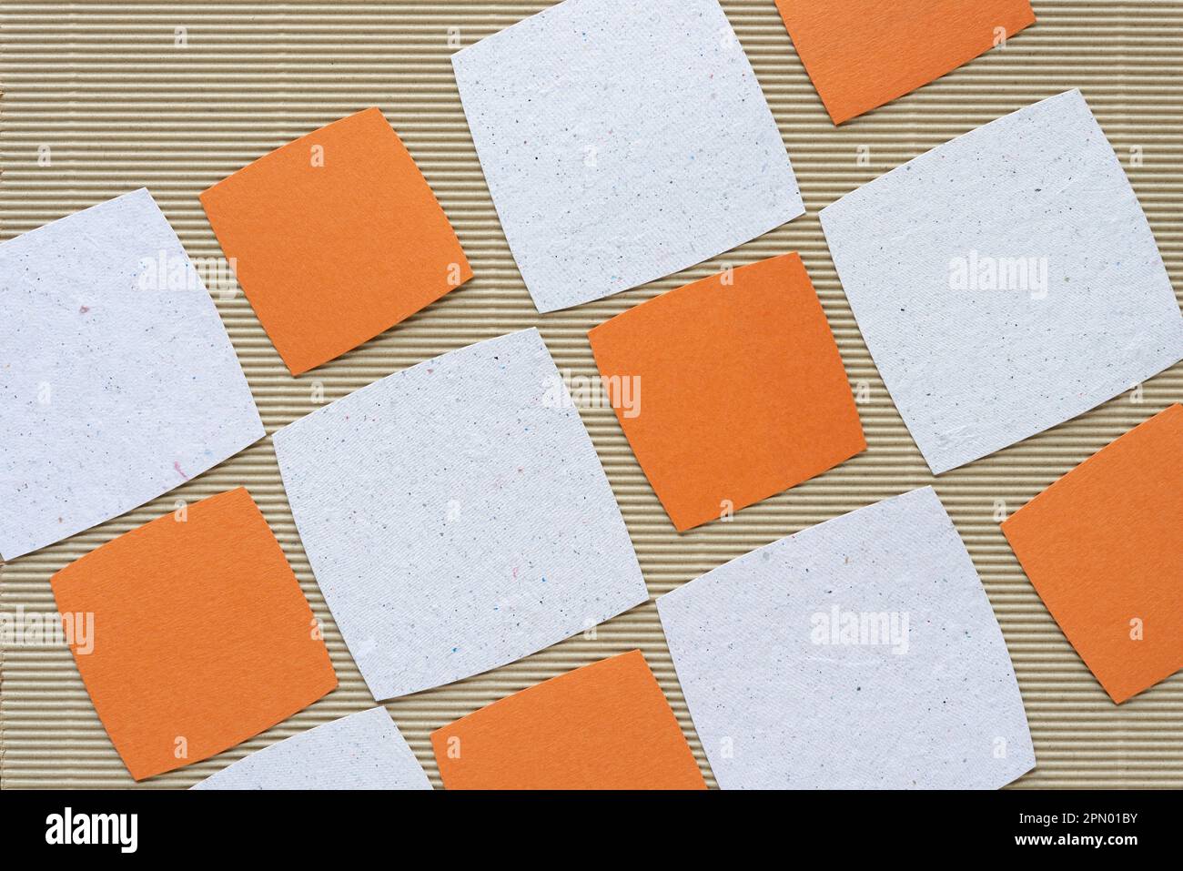 paper tiles in stone white and orange on beige corrugated cardboard ...