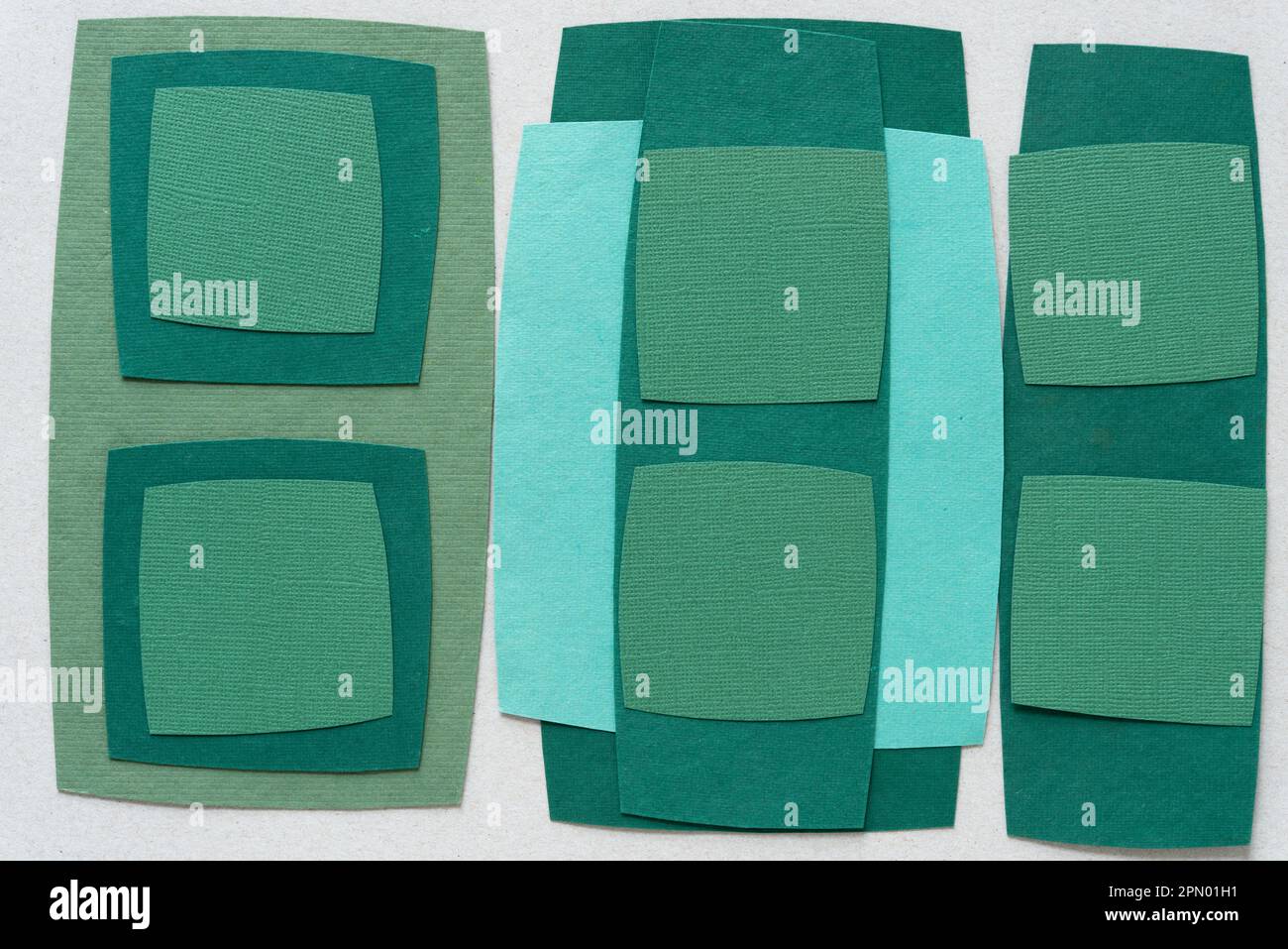 various shades of textured green paper shapes (mostly squares) on blank ...