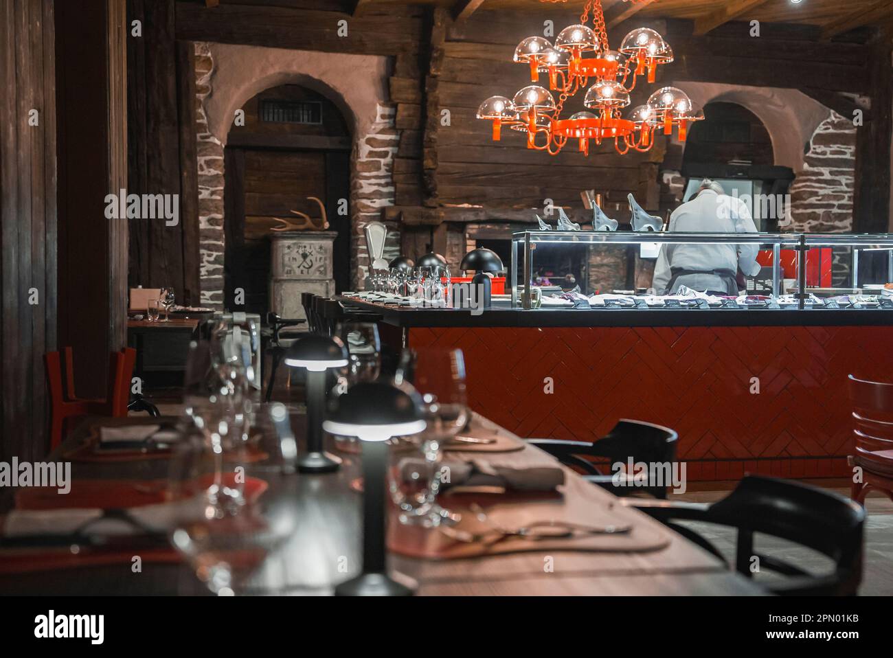 Chandelier hanging over chef working at food counter in restaurant ...