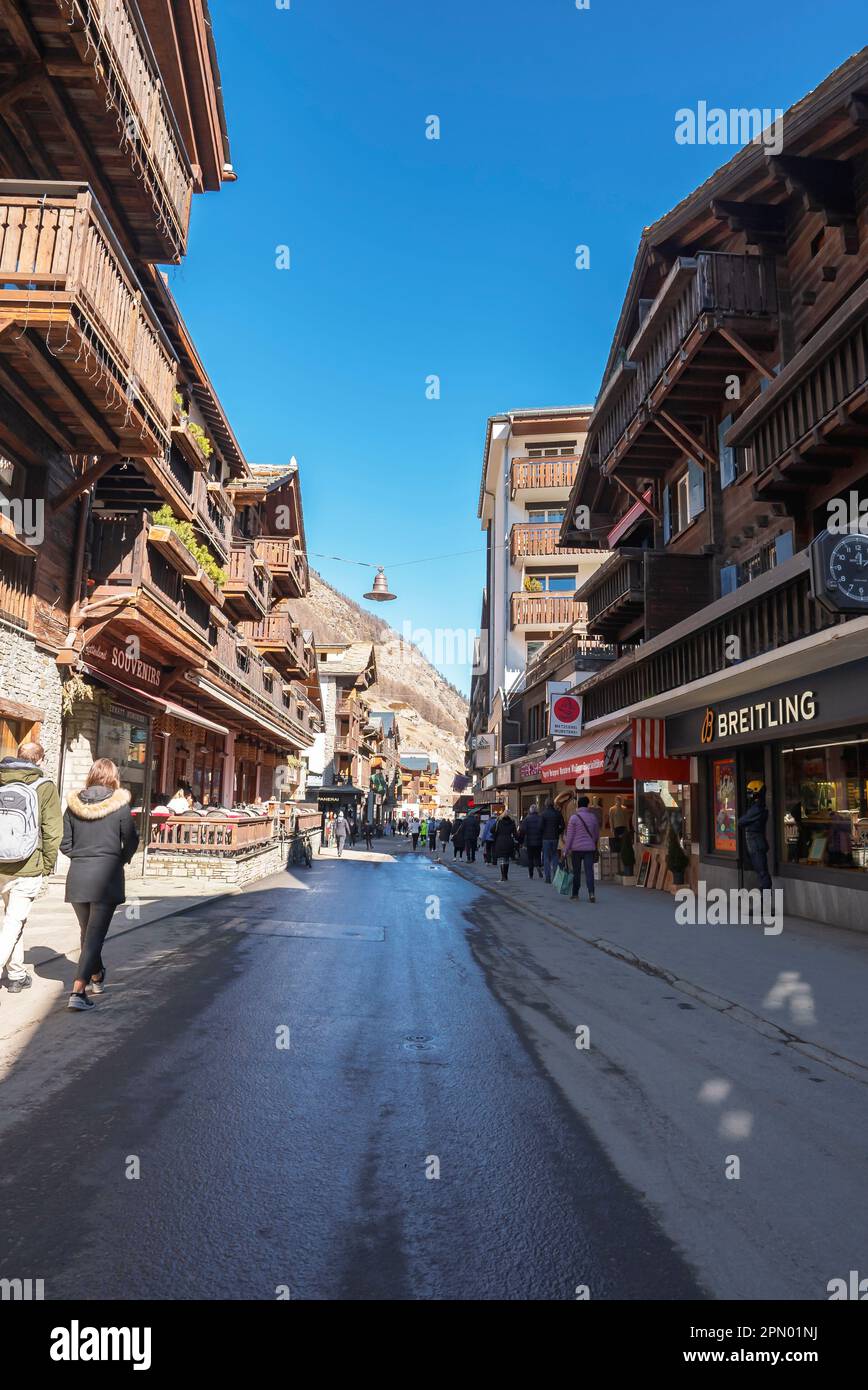 Tourists walking on street between hotel buildings in town Stock Photo ...