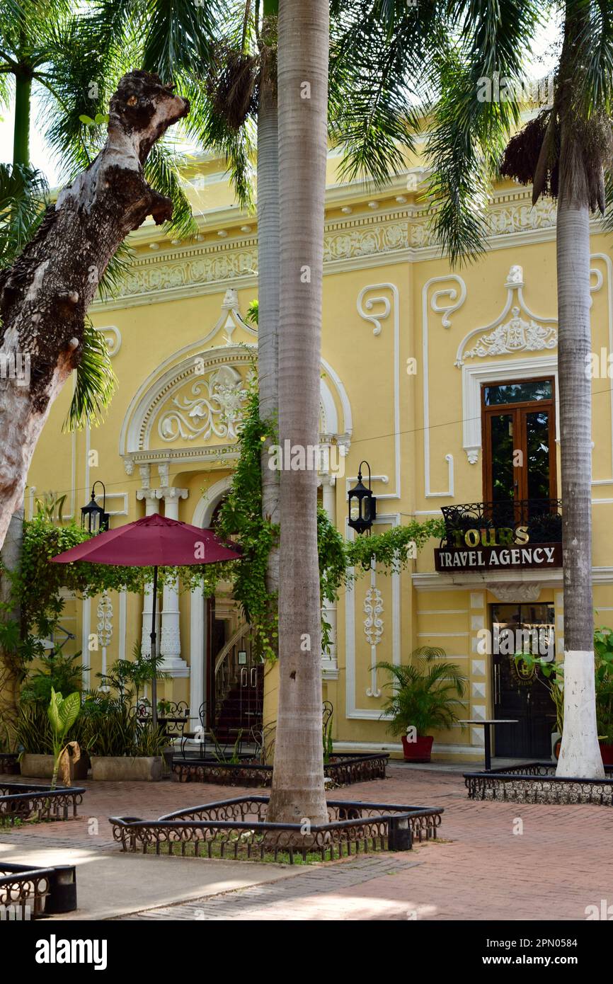 The beautiful, light yellow facade of a hotel facing Parque Hidalgo in ...