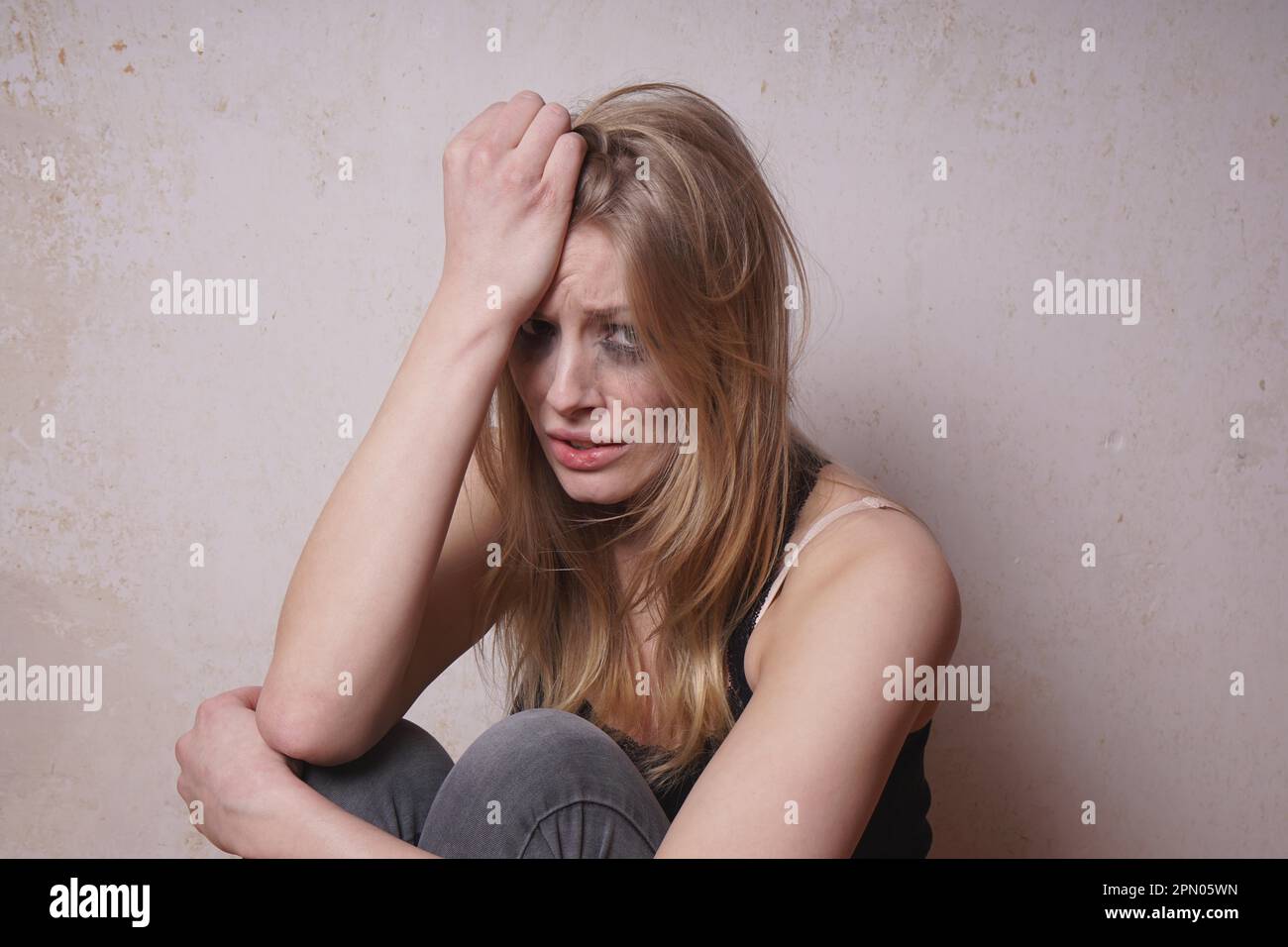 sad young woman with tear-stained face and smudgy makeup from crying ...