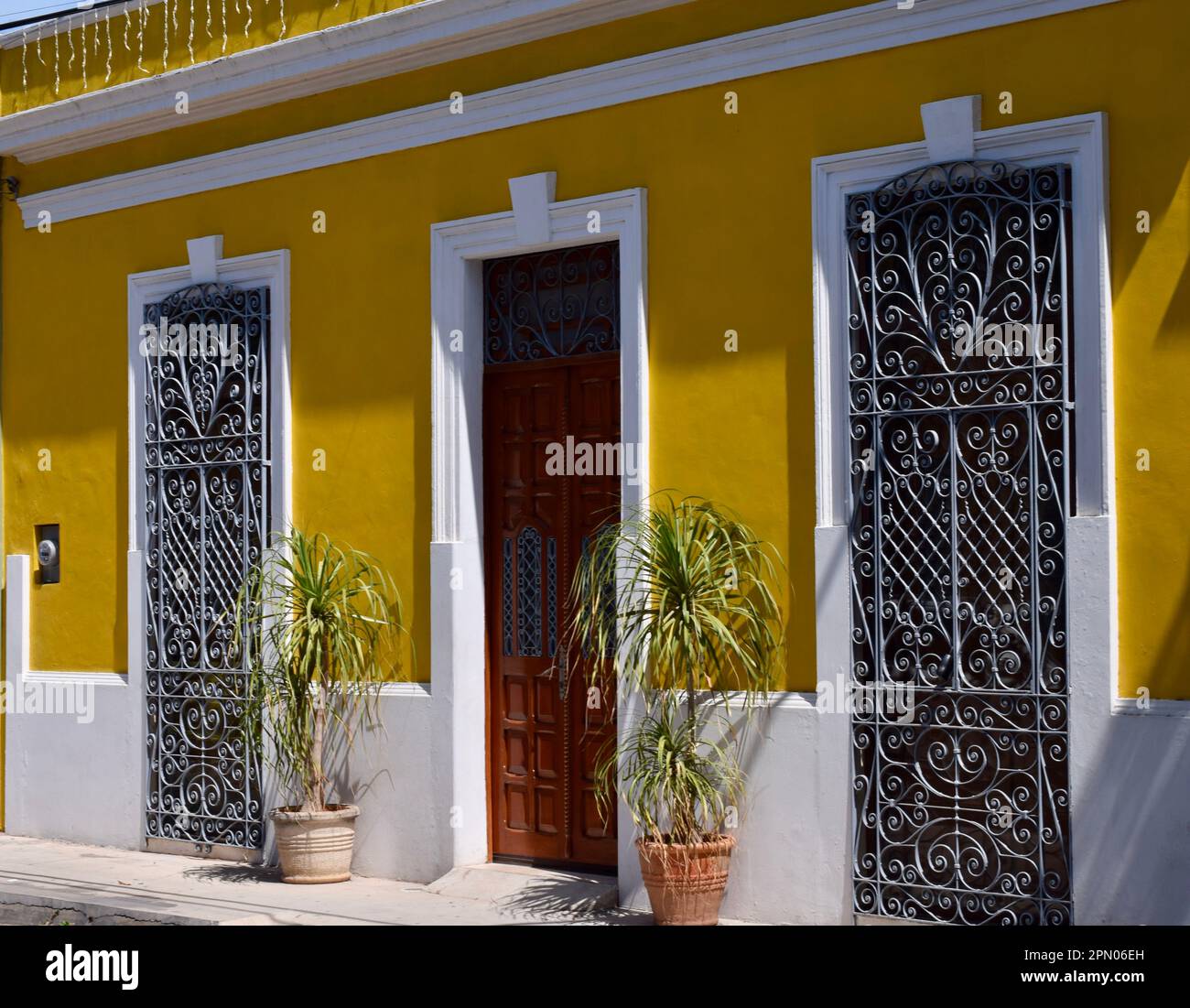 The beautiful facade of a yellow, restored building with wrought iron ...