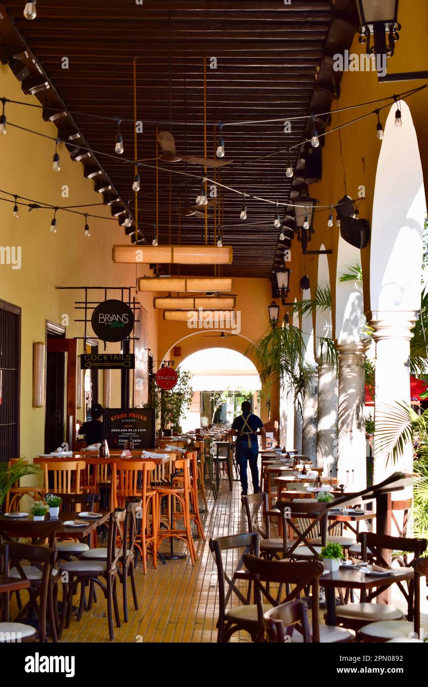 An arcade with restaurants, tables, and chairs on the side of parque ...