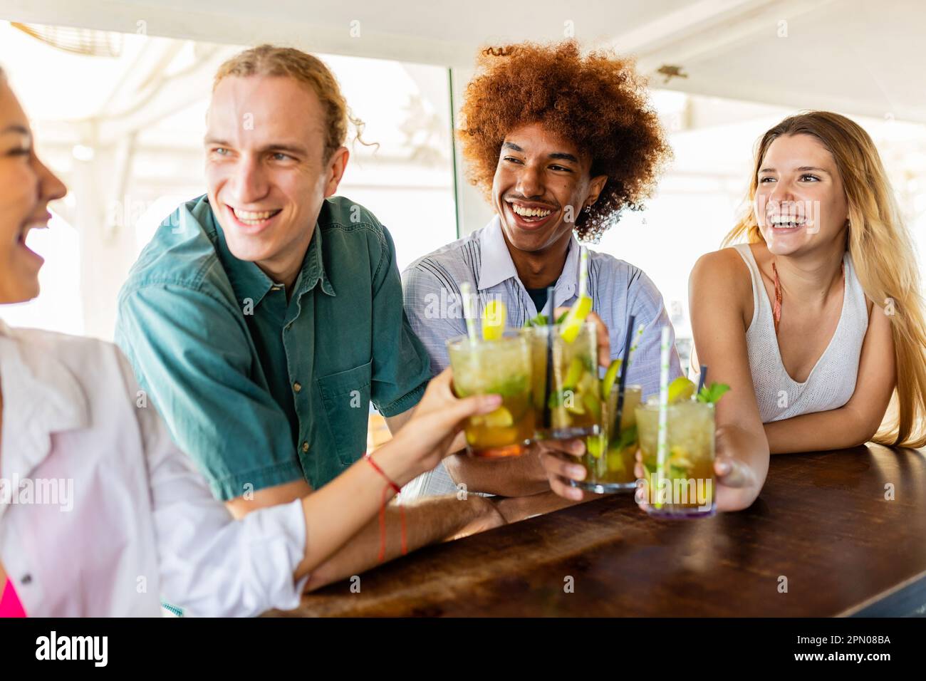 Multiracial young friends cheering with mojito cocktail at terrace ...