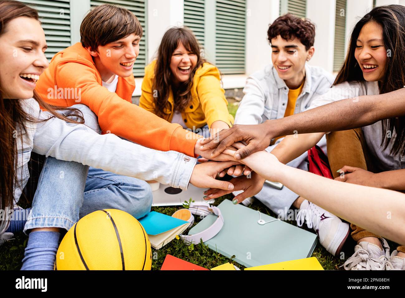Multiracial group of young student people stacking hands at college ...