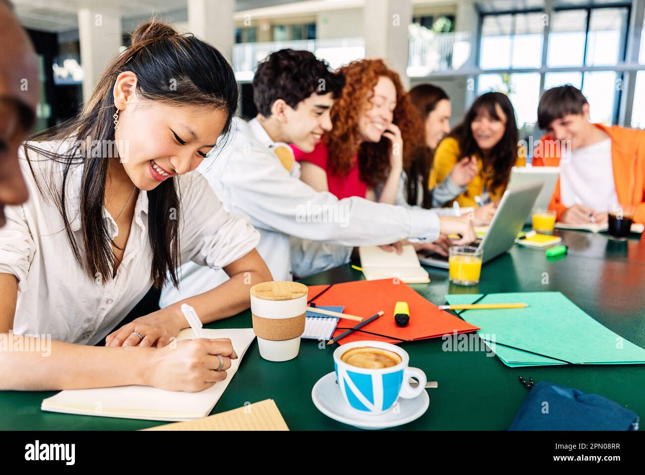 Young multiracial college students studying together at campus ...