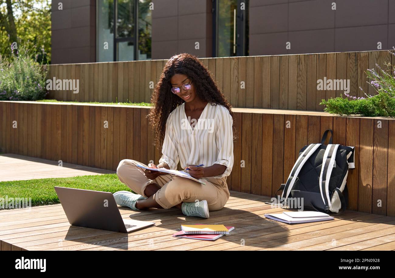 African girl student learning online using laptop studying outside ...