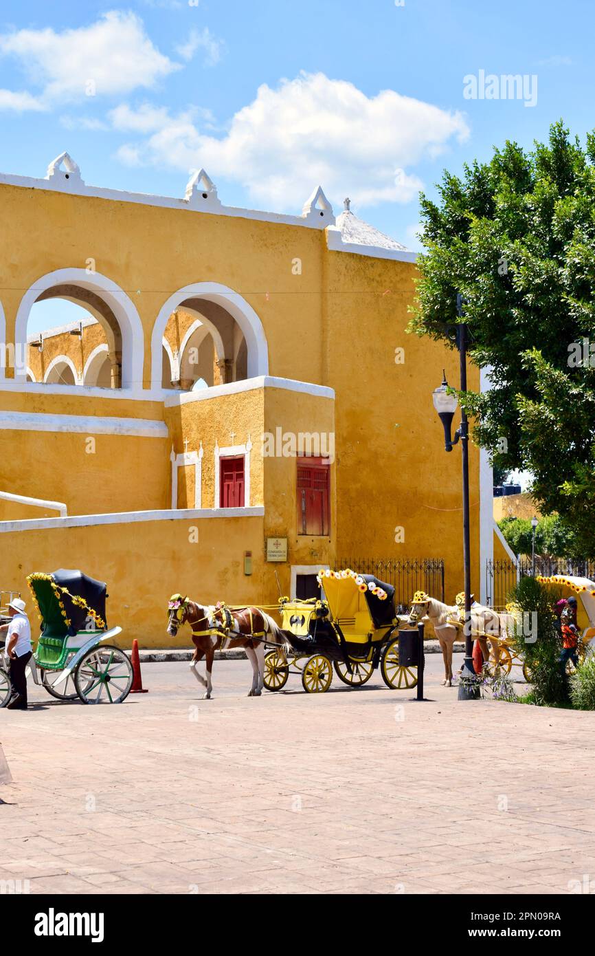The colorful horse-drawn carriages for tourists in the historic, yellow ...