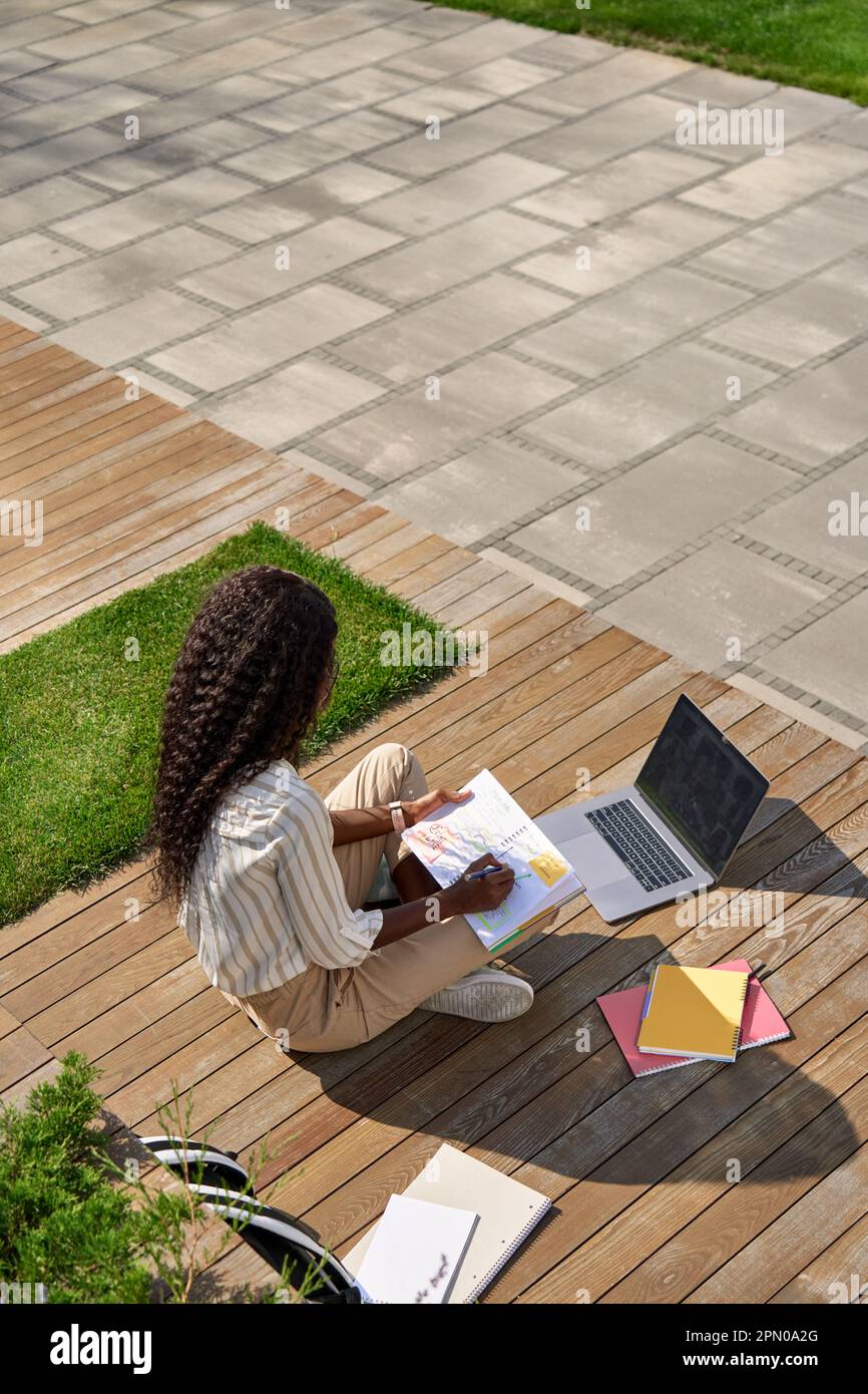 Black young woman student learning using laptop studying outside campus ...