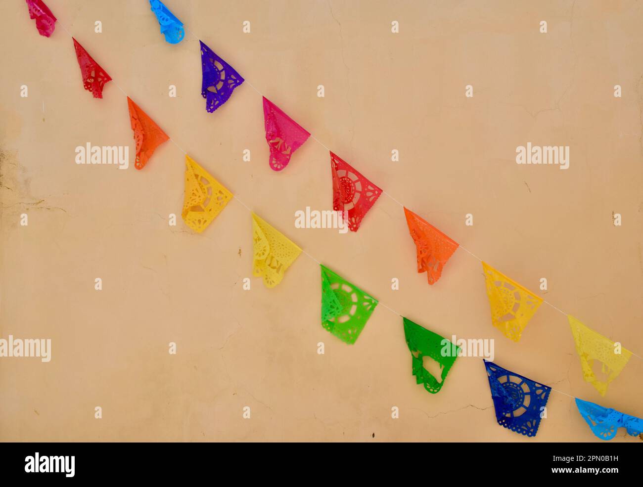 Colorful papel picado (perforated paper) against a wall in the yellow ...