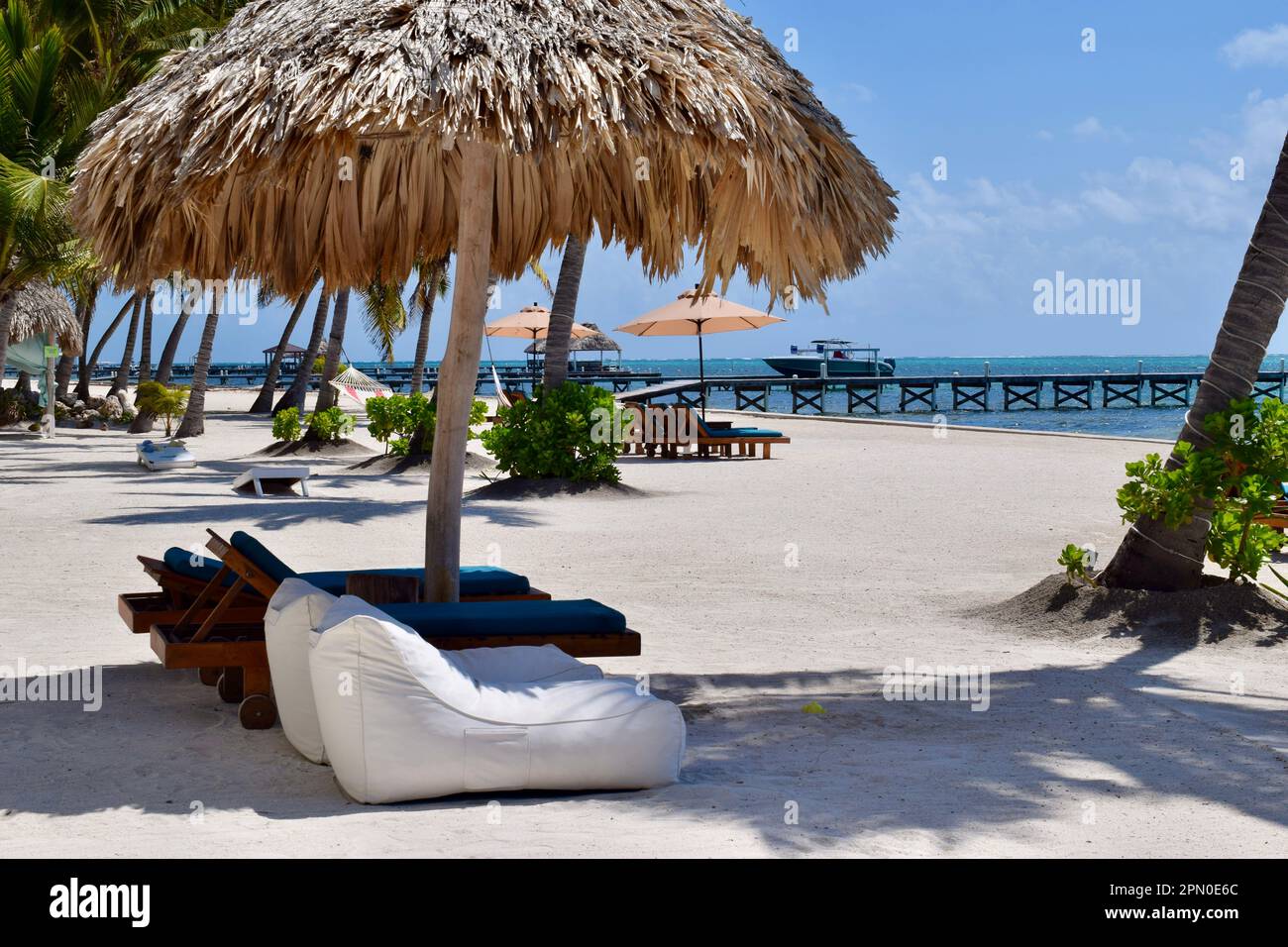 Comfortable beach and lounge chairs under a palapa on a sunny day at ...
