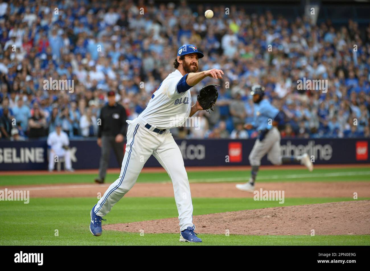 Toronto Blue Jays pitcher Jordan Romano throws to first base to force ...