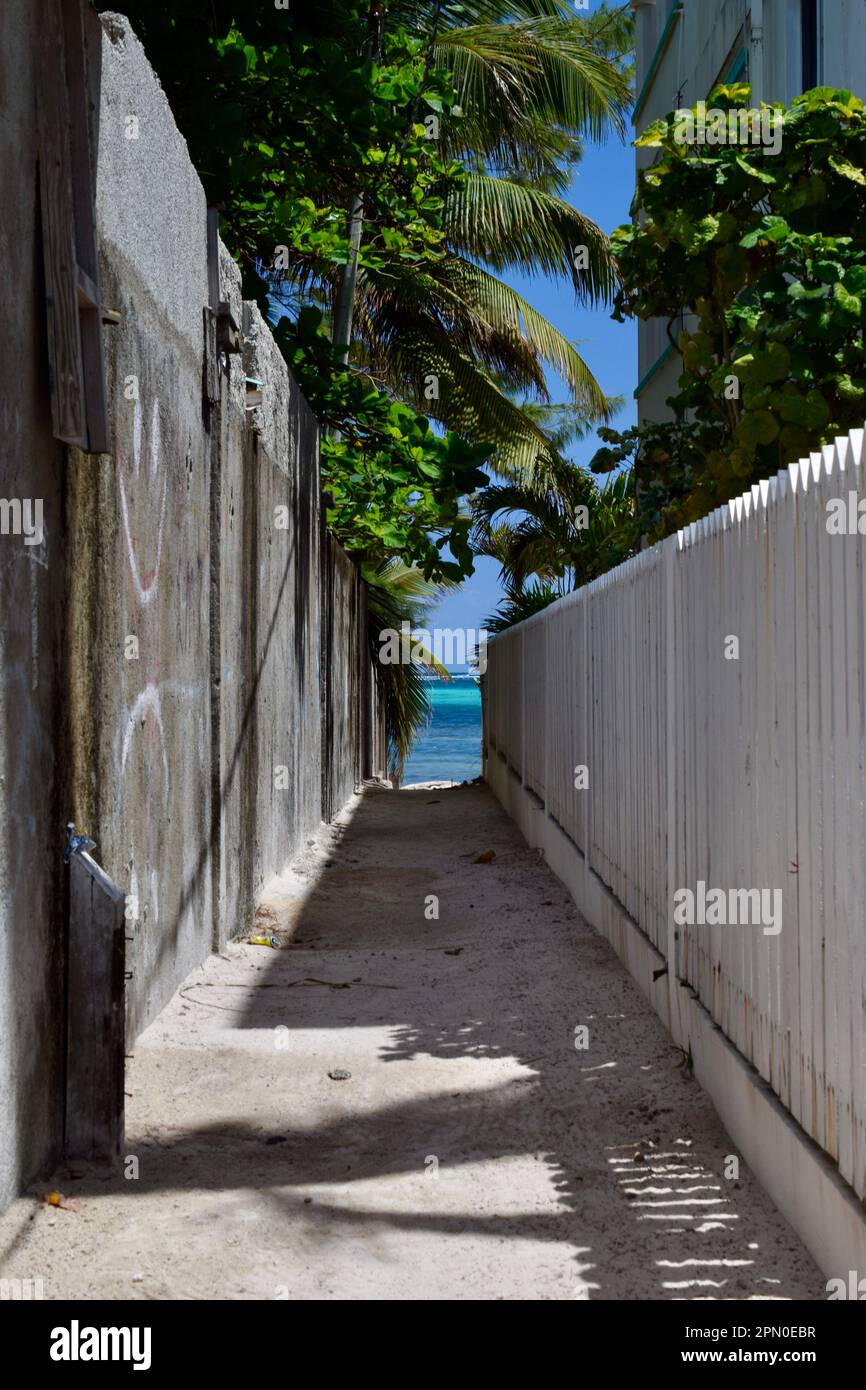 A narrow alley leading to the beach and tropical-blue water, in San ...