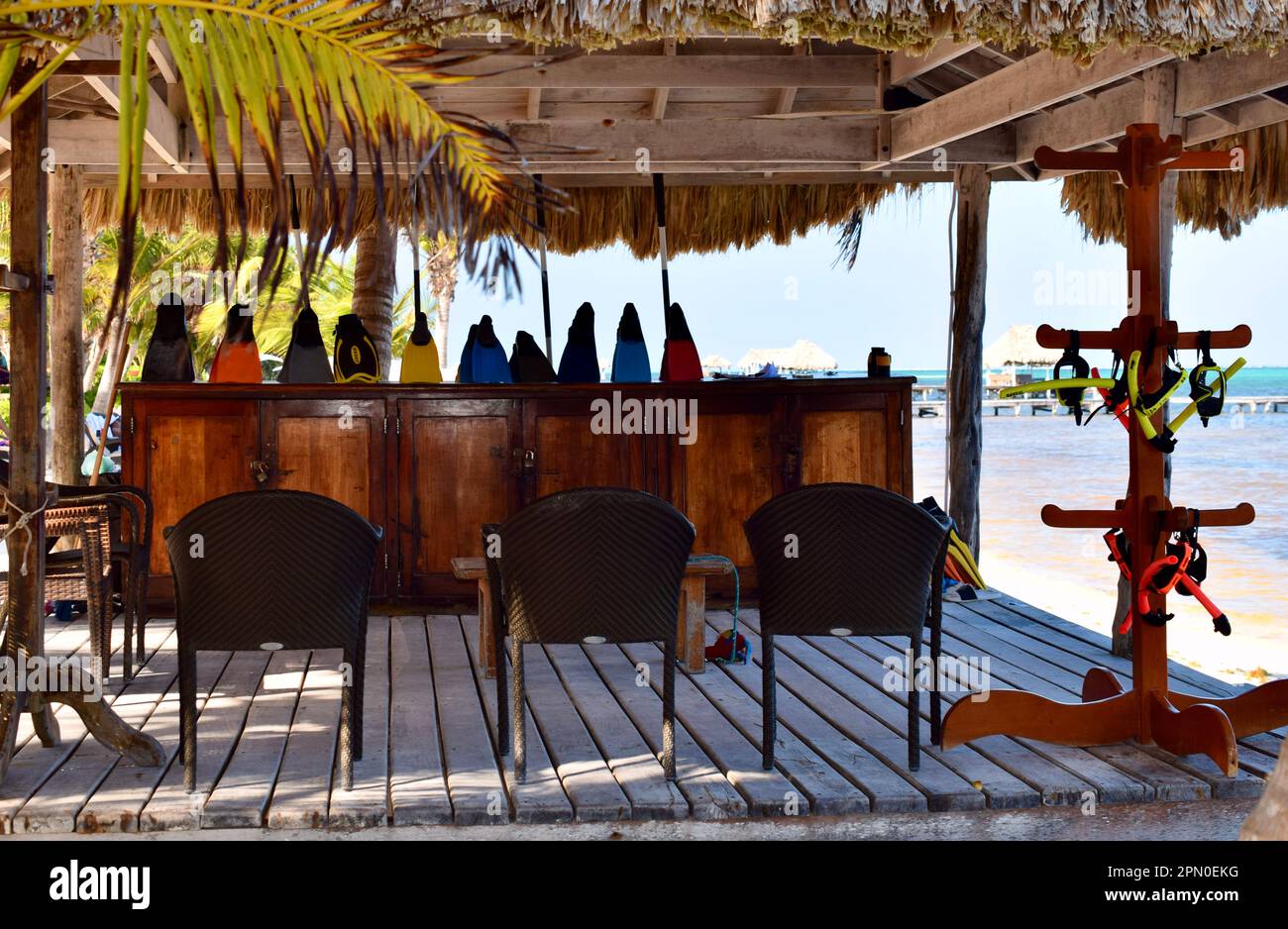 Snorkeling gear and chairs, under a palapa, at the beach on a sunny day ...