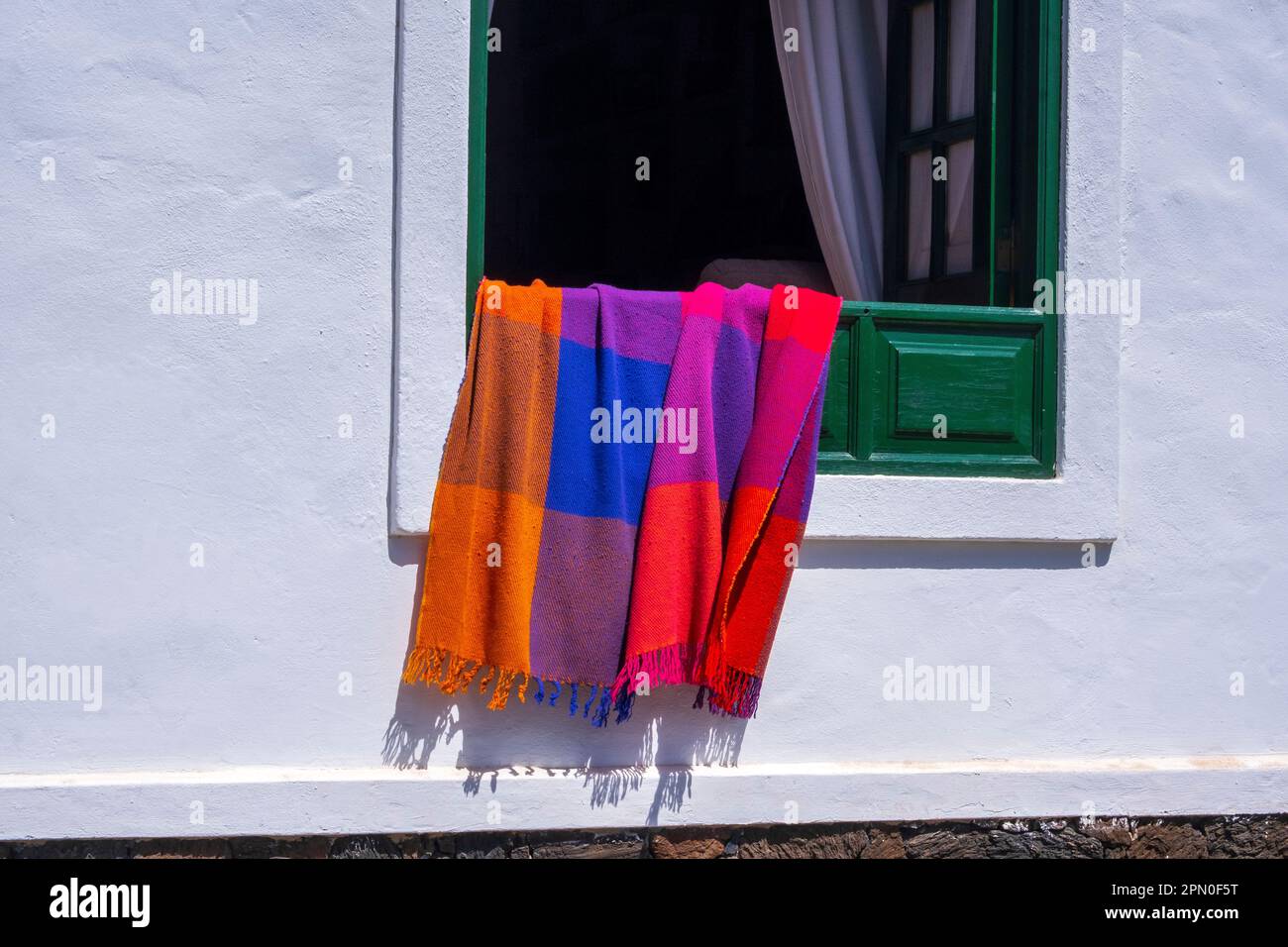 Colorful blanket hanging out of a window on Lanzarote, Canary Islands ...