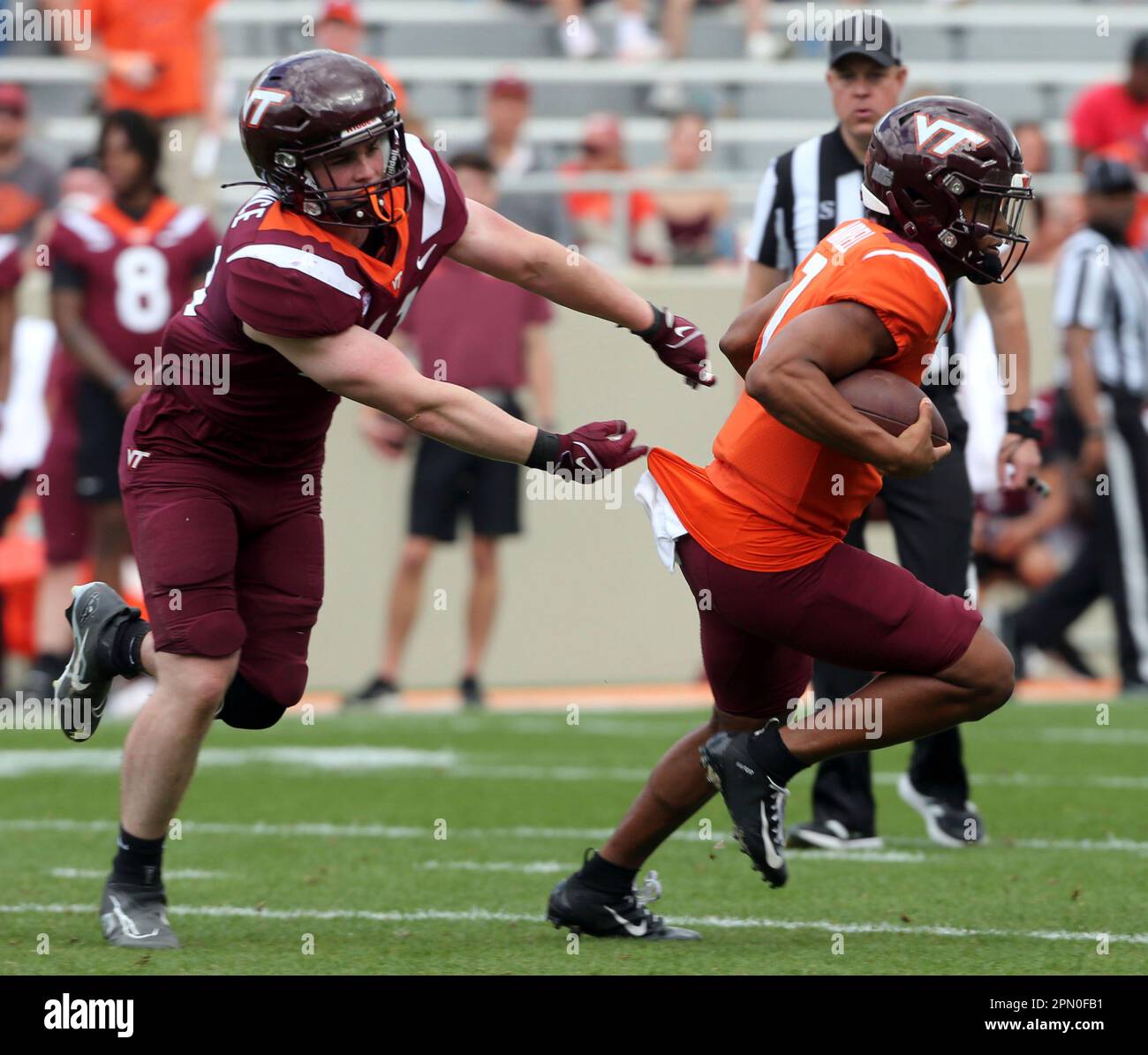 Virginia Tech quarterback Devin Farrell, right, is stopped from behind ...