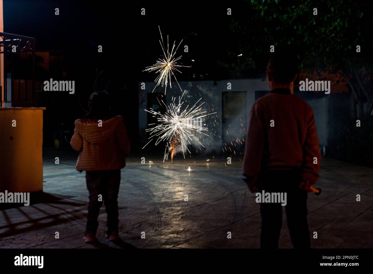 Limassol, Cyprus. 15th Apr, 2023. Two children watch a firecracker go ...