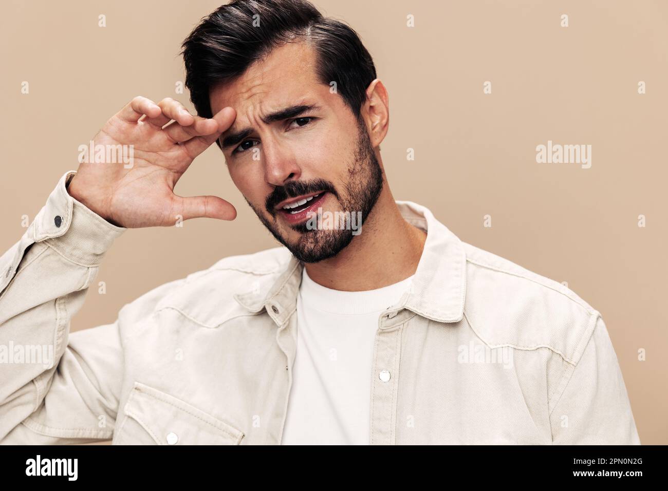 Portrait of a stylish man dissatisfied and angry screaming on a beige ...