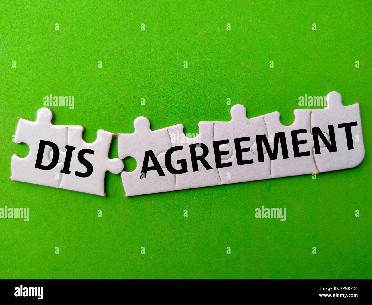 White puzzle with the word DISAGREEMENT on a green background Stock ...