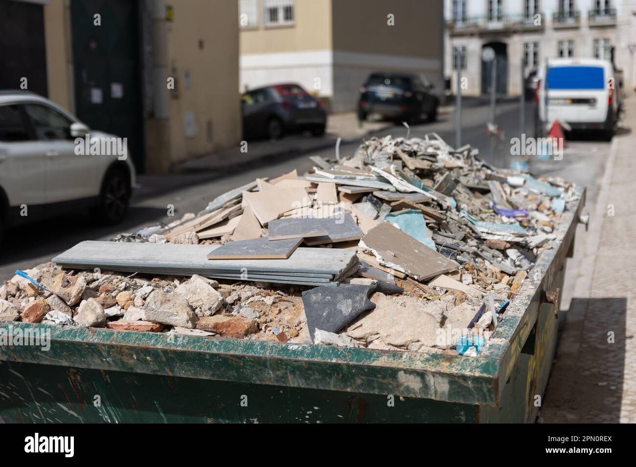 Construction waste in a container on the street. Mid shot Stock Photo ...