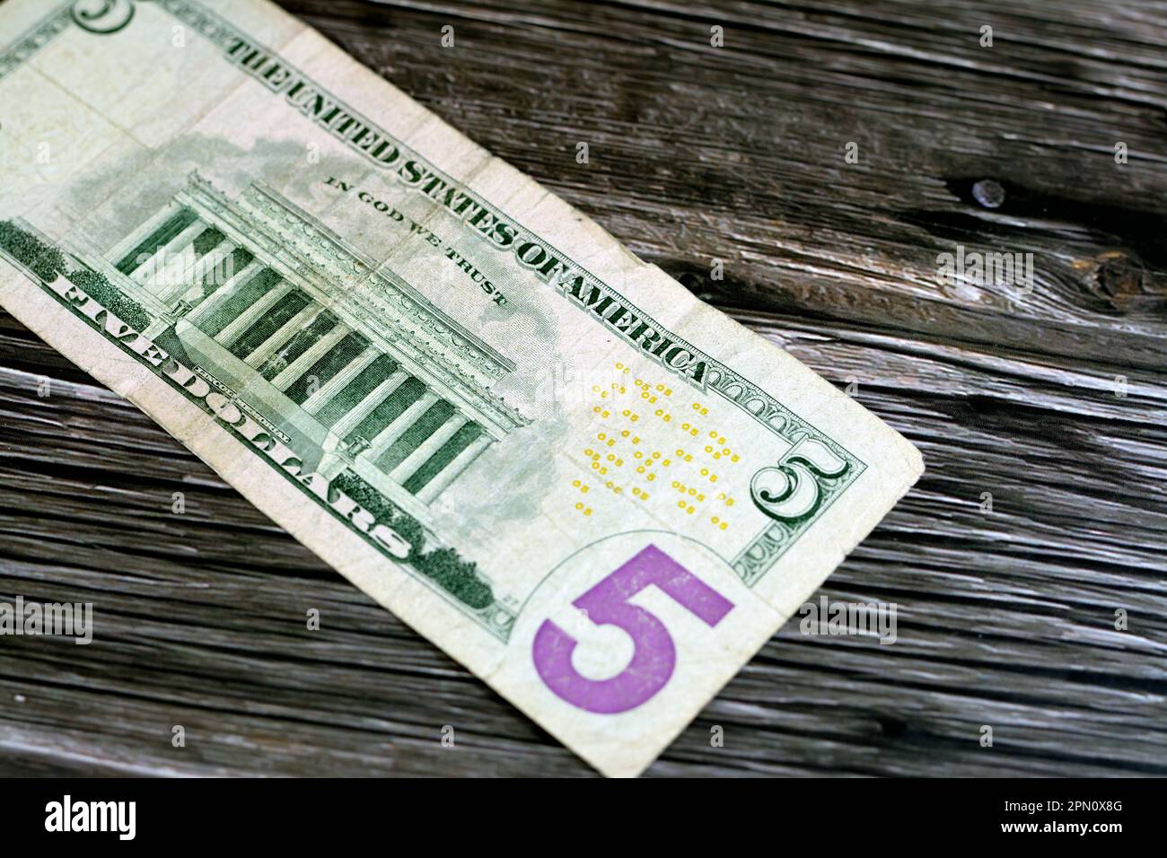 Reverse side of a torn 5 five dollars bill banknote repaired with ...