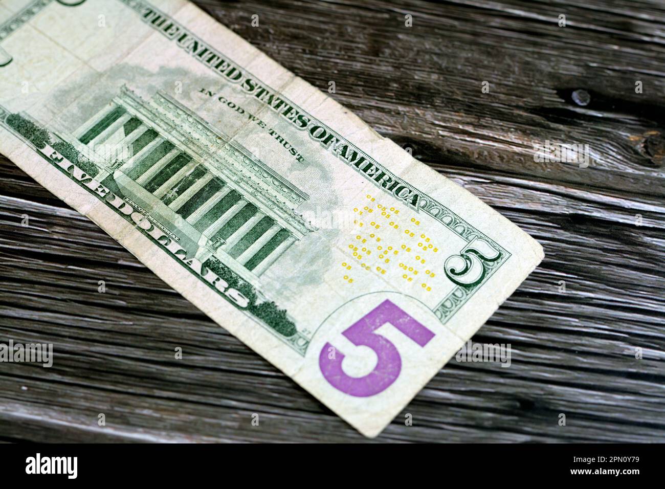 Reverse side of a torn 5 five dollars bill banknote repaired with ...