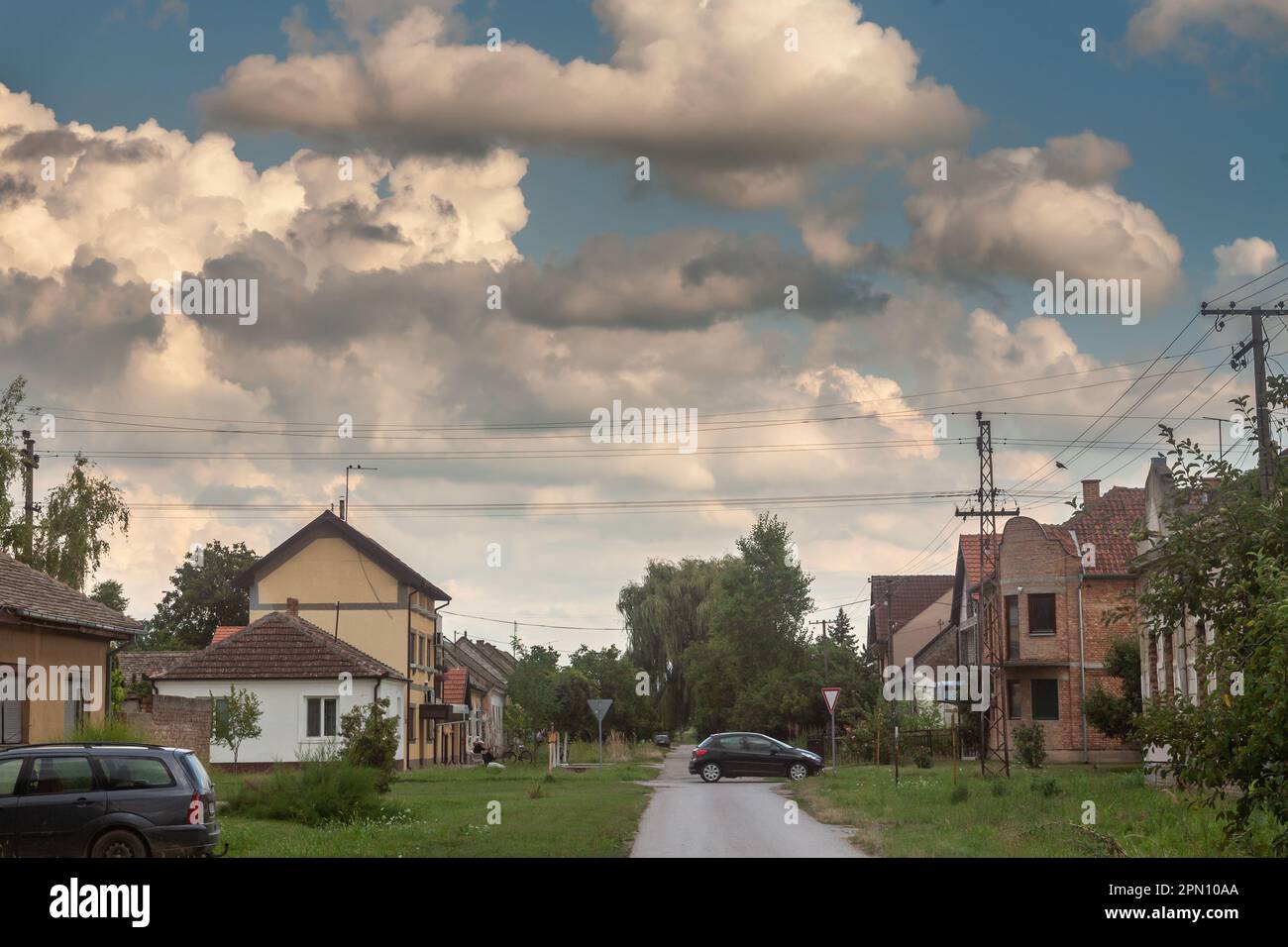Picture of the streets of a rural village, Alibunar, with cars passing ...