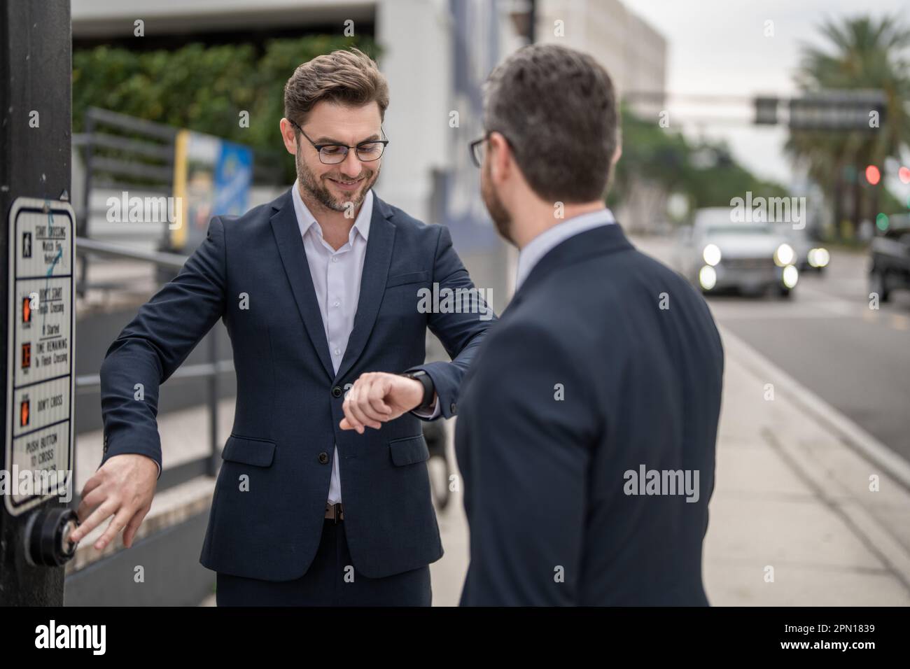 happy businessmen check time at street light. businessmen check time ...