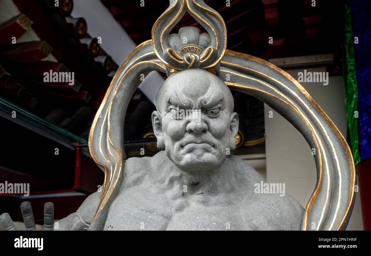 Gray statue with golden trim at a Buddhist temple in Singapore Stock ...