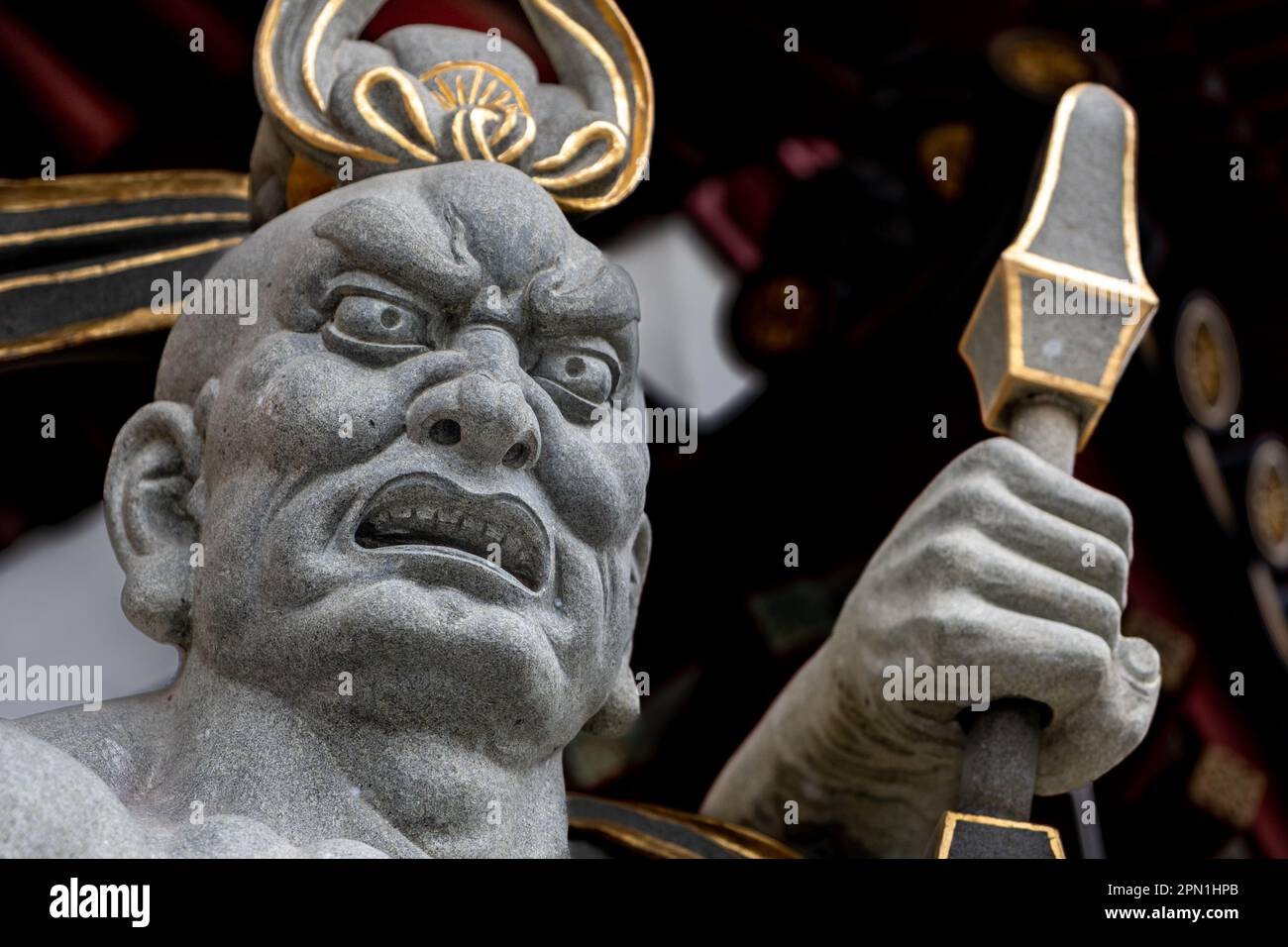 Gray statue with golden trim at a Buddhist temple in Singapore Stock ...