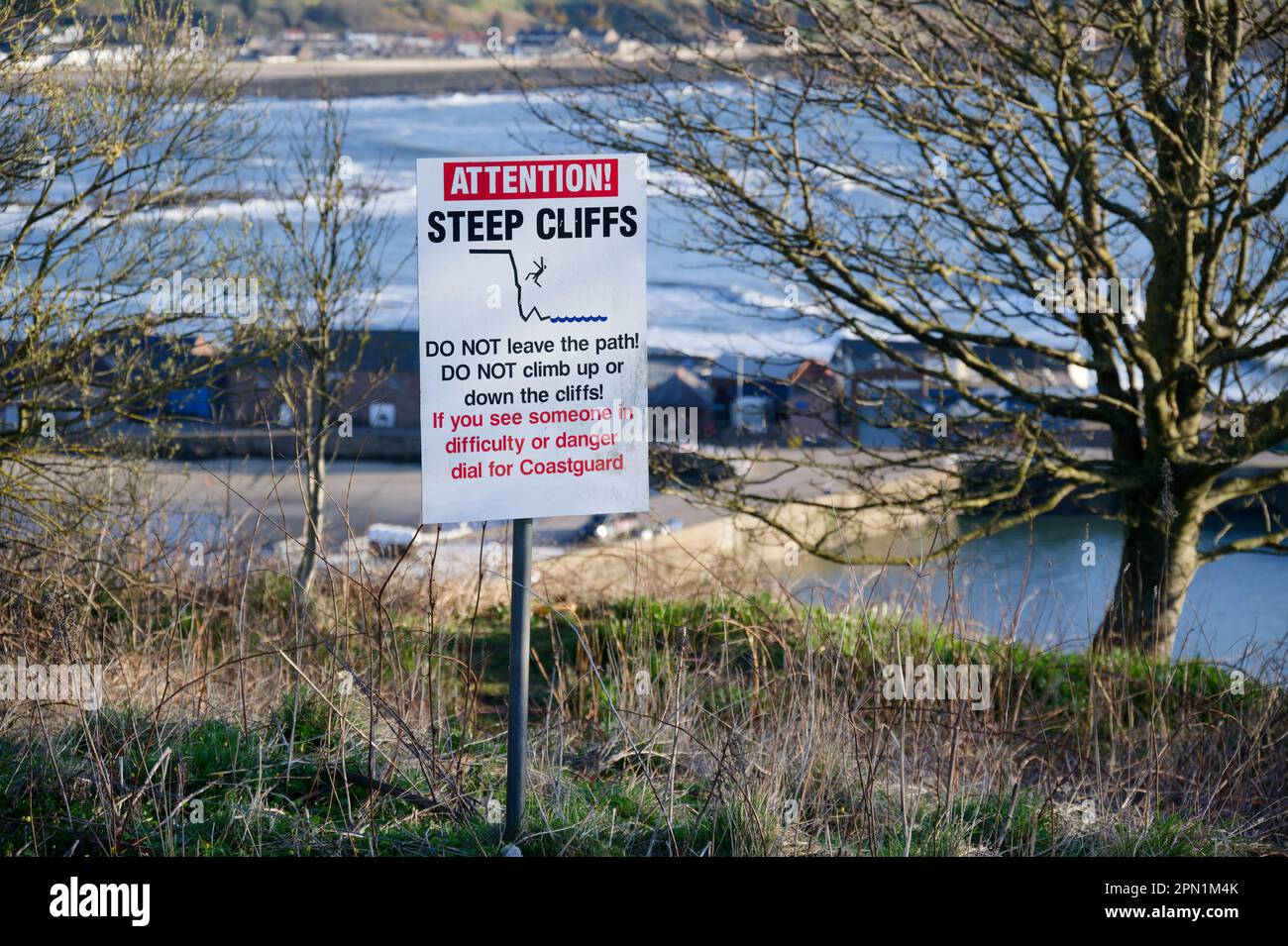 Steep cliffs warning sign for tourists high above Stonehaven harbour ...