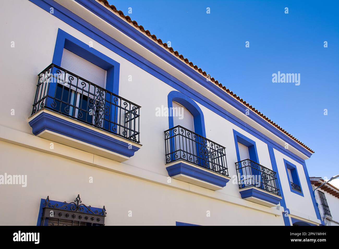 Facade of a house with blue framed windows, typical of Spain Stock ...