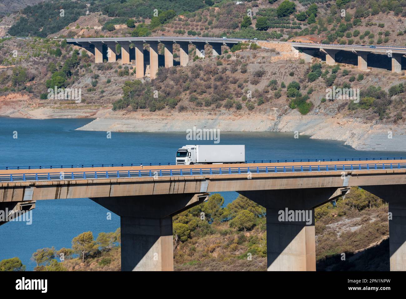 Truck with a refrigerated semi-trailer driving through a viaduct over a ...