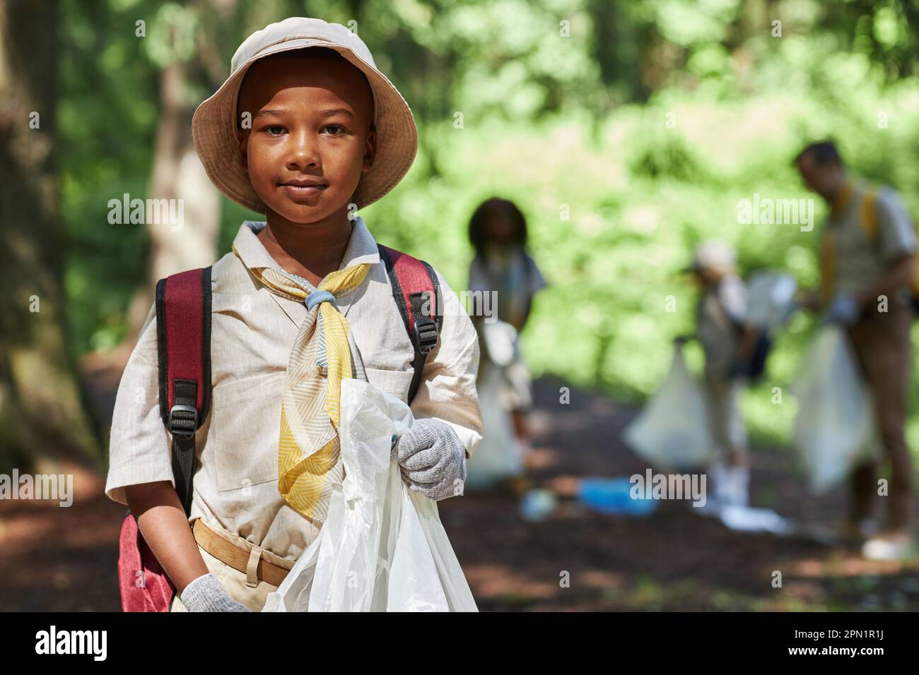 Waist up portrait of cute black boy as scout looking at camera in ...