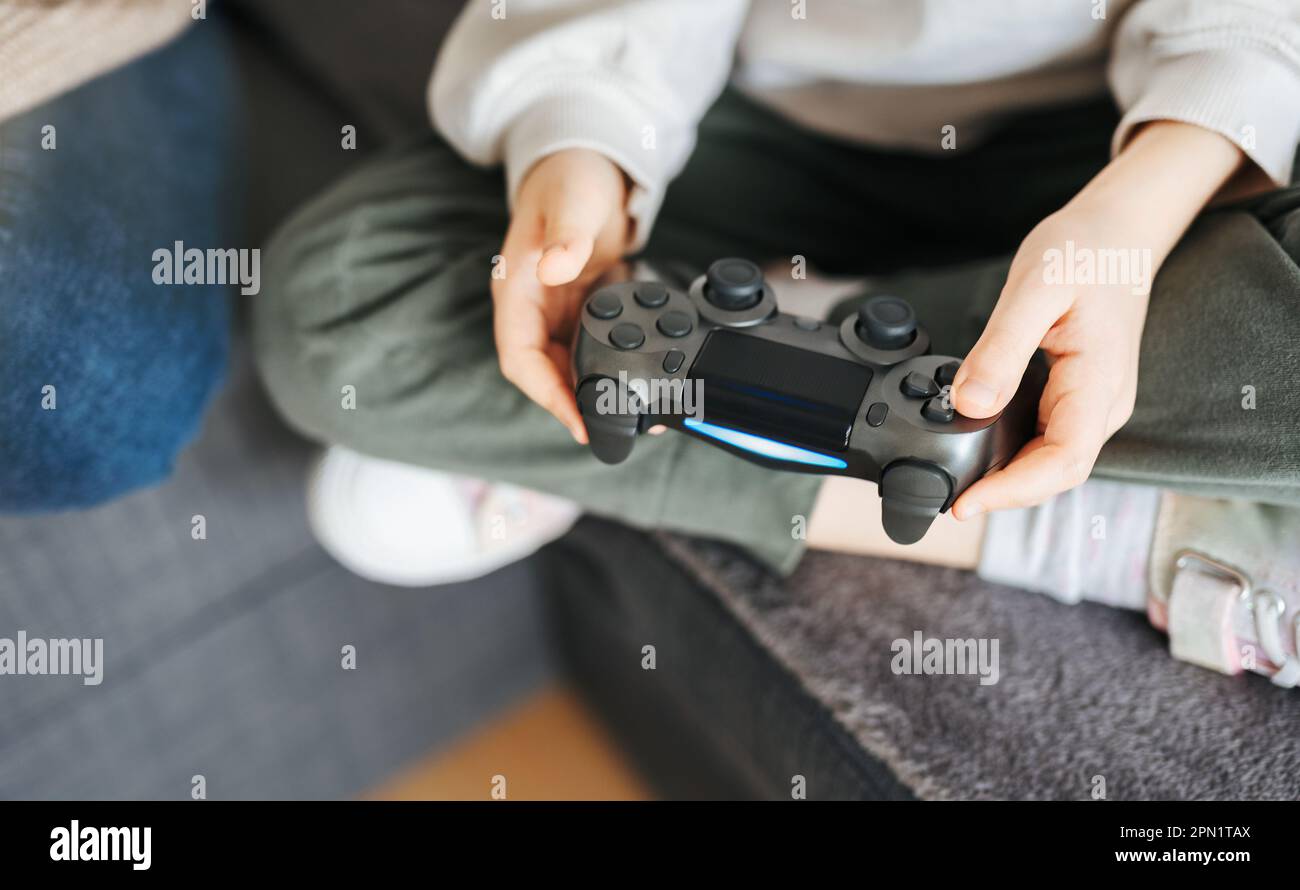 A little girl holding game controller playing video games Stock Photo ...