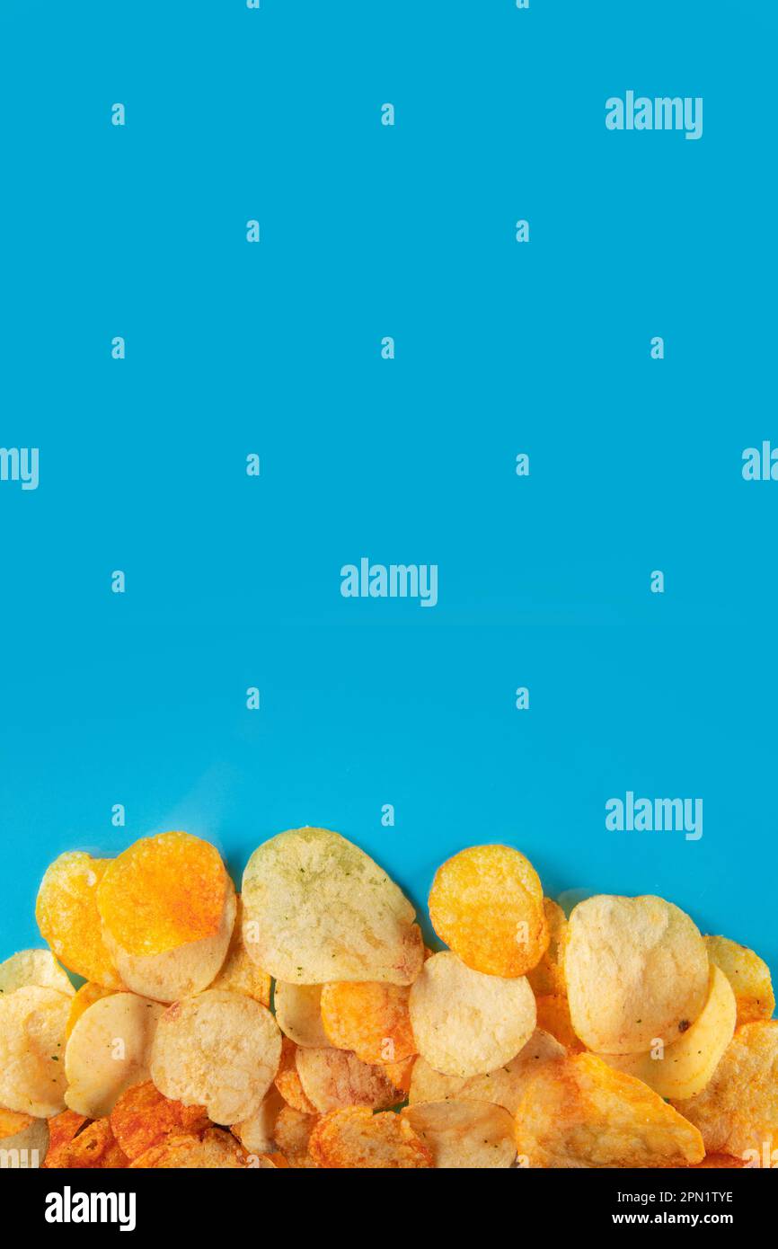 Border of potato chips isolated on vibrant blue background. Organic and ...