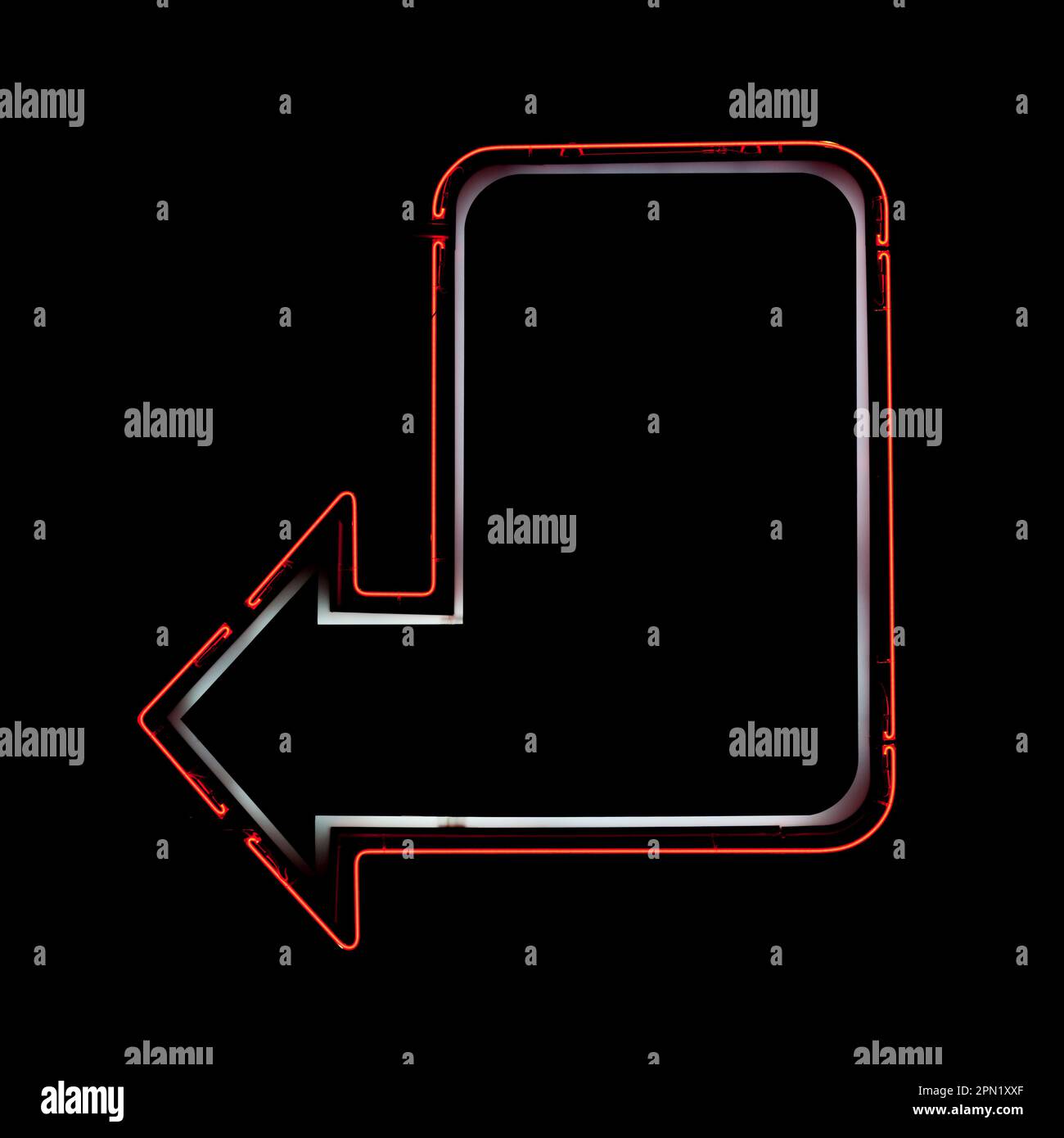 Big red neon light shaped into an arrow turning left isolated on a ...