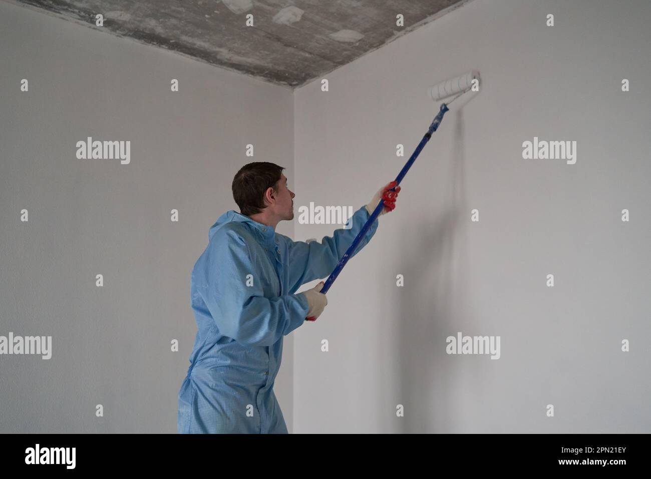 Man paints the ceiling with a roller. Concept of home makeover and ...