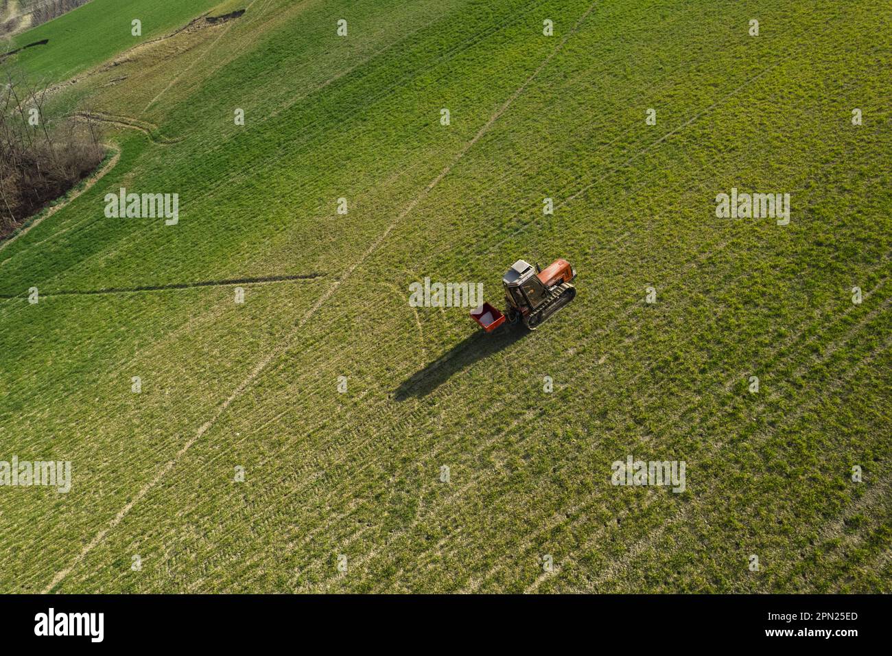 farmer driving uphill crawled tractor in the farm during spring season ...