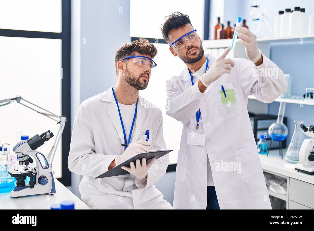 Young couple wearing scientist uniform working at laboratory Stock ...