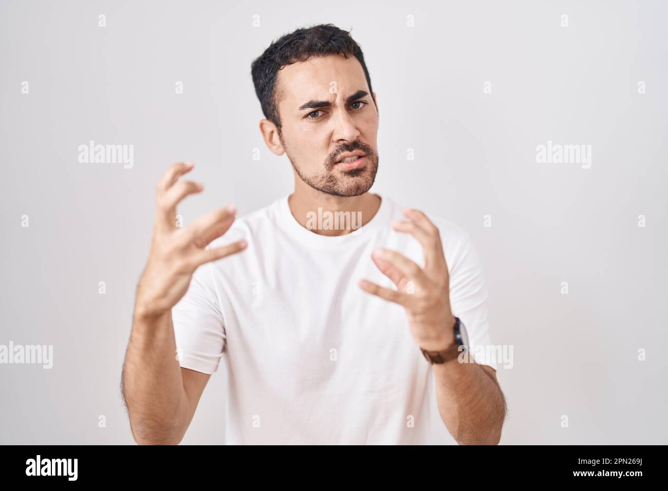 Handsome hispanic man standing over white background shouting ...